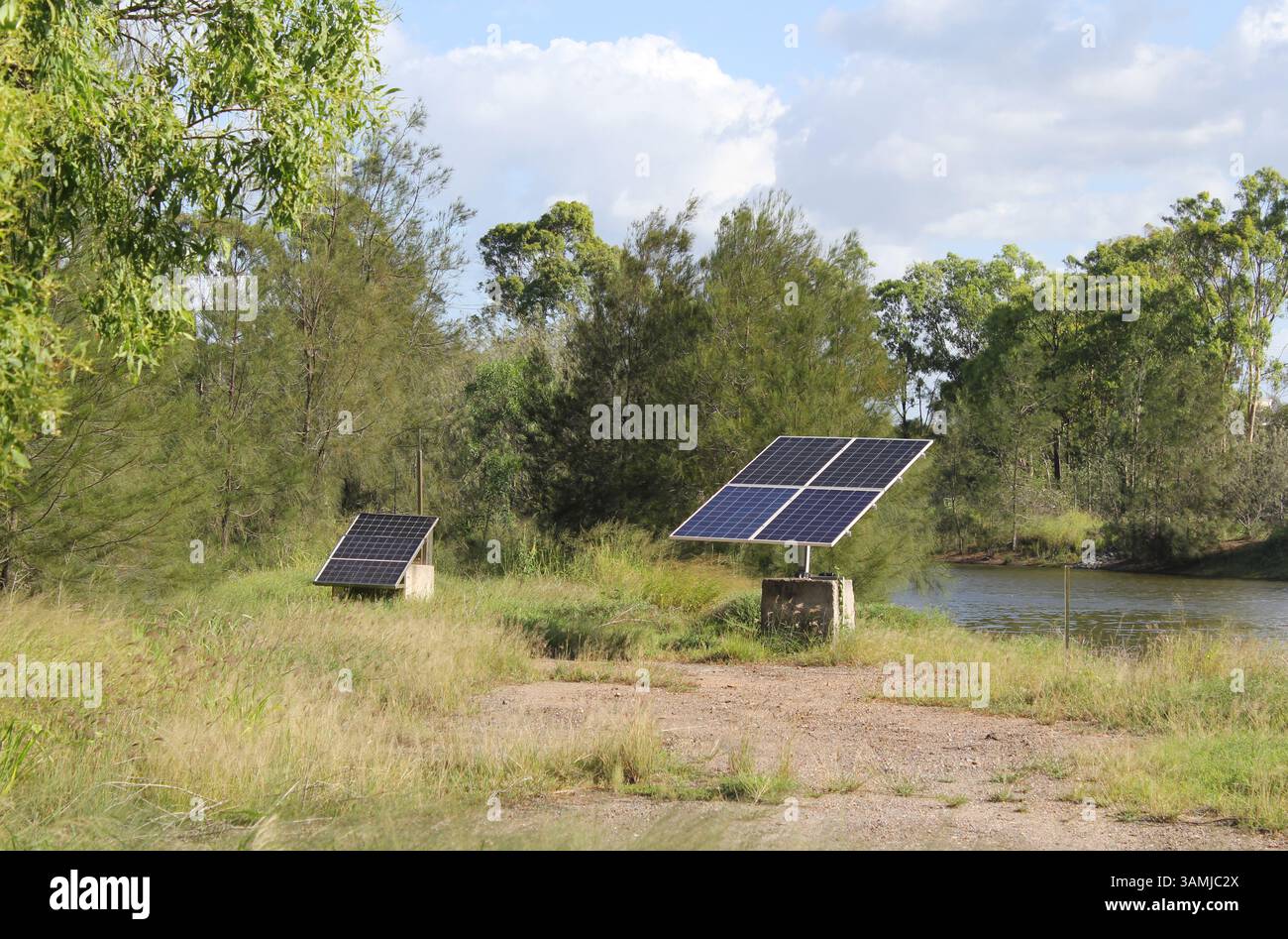 Two solar water pump panels next to a pond surrounded by trees Stock ...