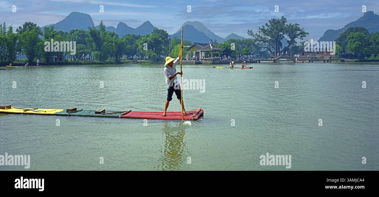 Chinese man on a raft on the lake in front of the stalactite cave ...