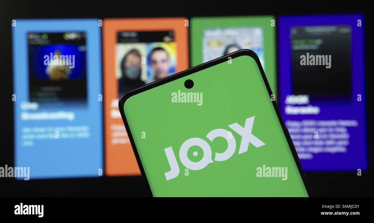 The logo of the joox is displayed on a smartphone screen, and the ...