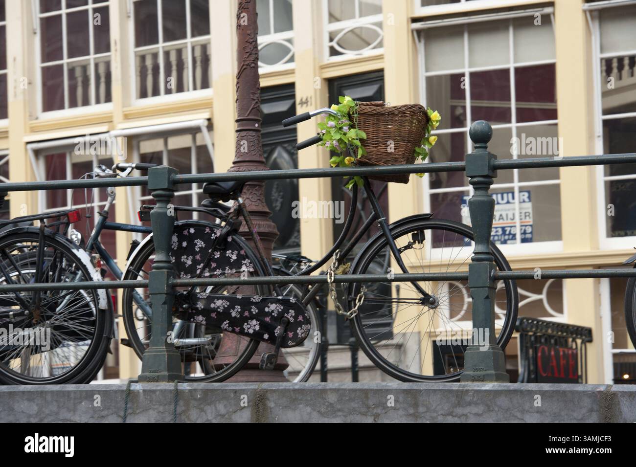 Fiets met bloemen en mand op brug langs de Amsterdamse gracht Stock ...