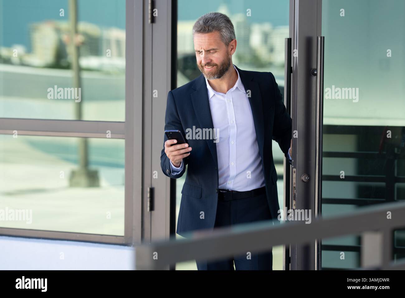 Business man entering an office building. Mature businessman walking ...