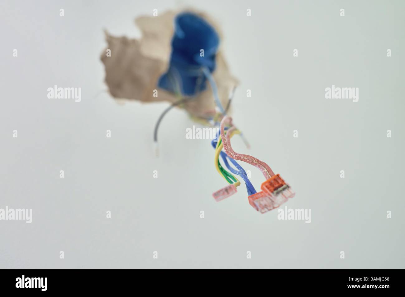 Colorful wires stick out of wall socket during renovation. Concept of ...