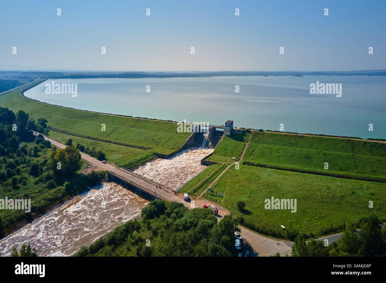 Aerial view of large dam discharging water into channel, managing water ...