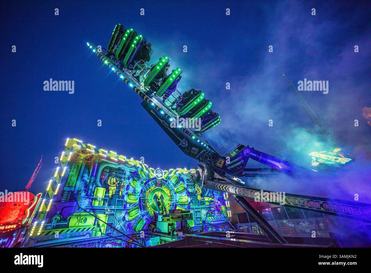 Smoke filled ride, as people young and old enjoy the fairground rides ...