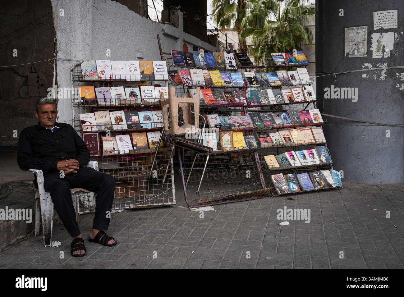 Damascus, Syria. 18th Mar, 2025. A Syrian book vendor sits by his ...