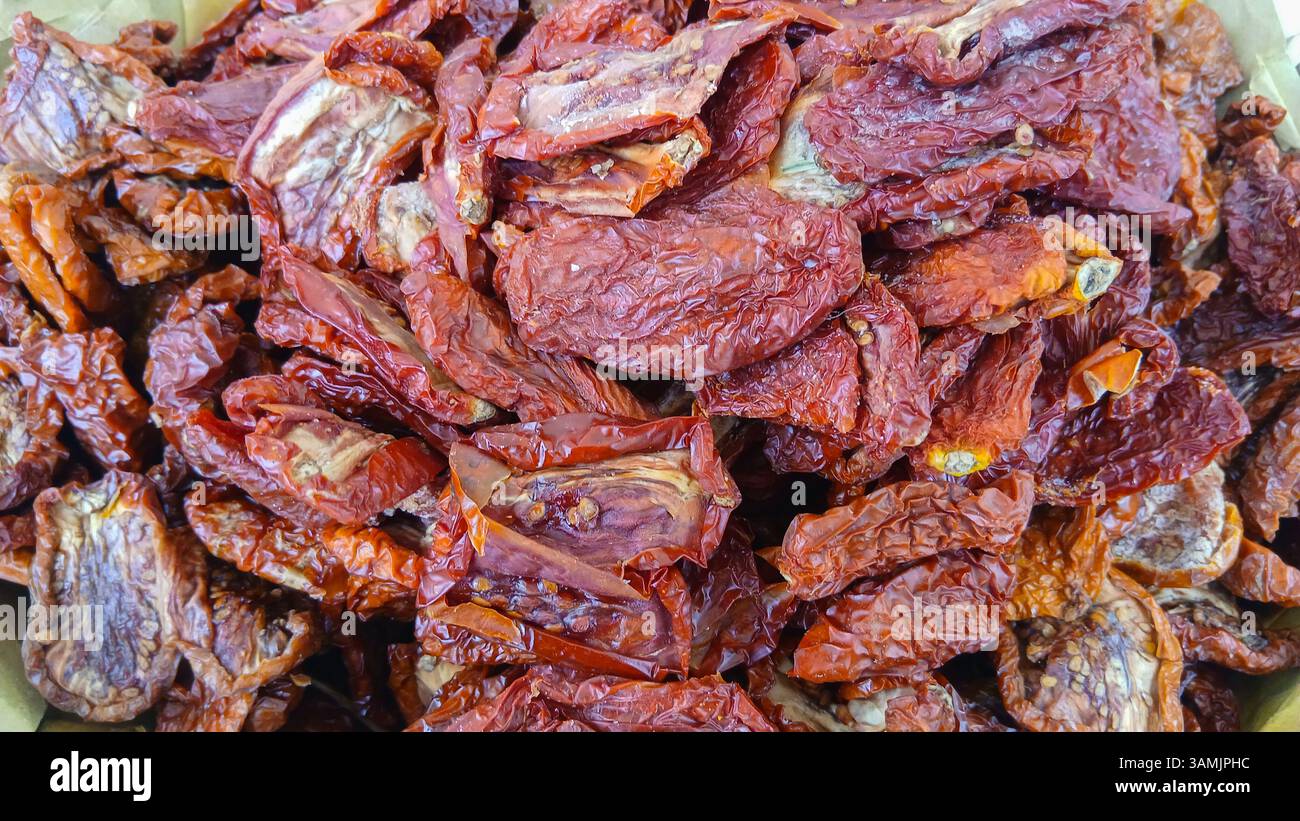 Sun-dried tomatoes are piled high, showcasing their rich color and ...