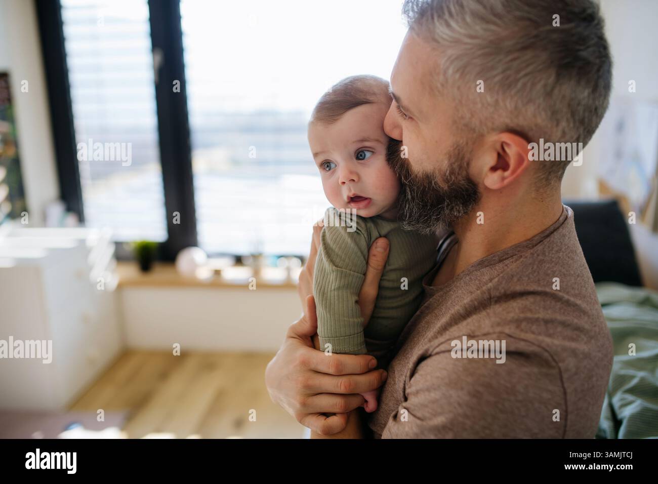 Portrait of father holding baby son in arms Stock Photo - Alamy