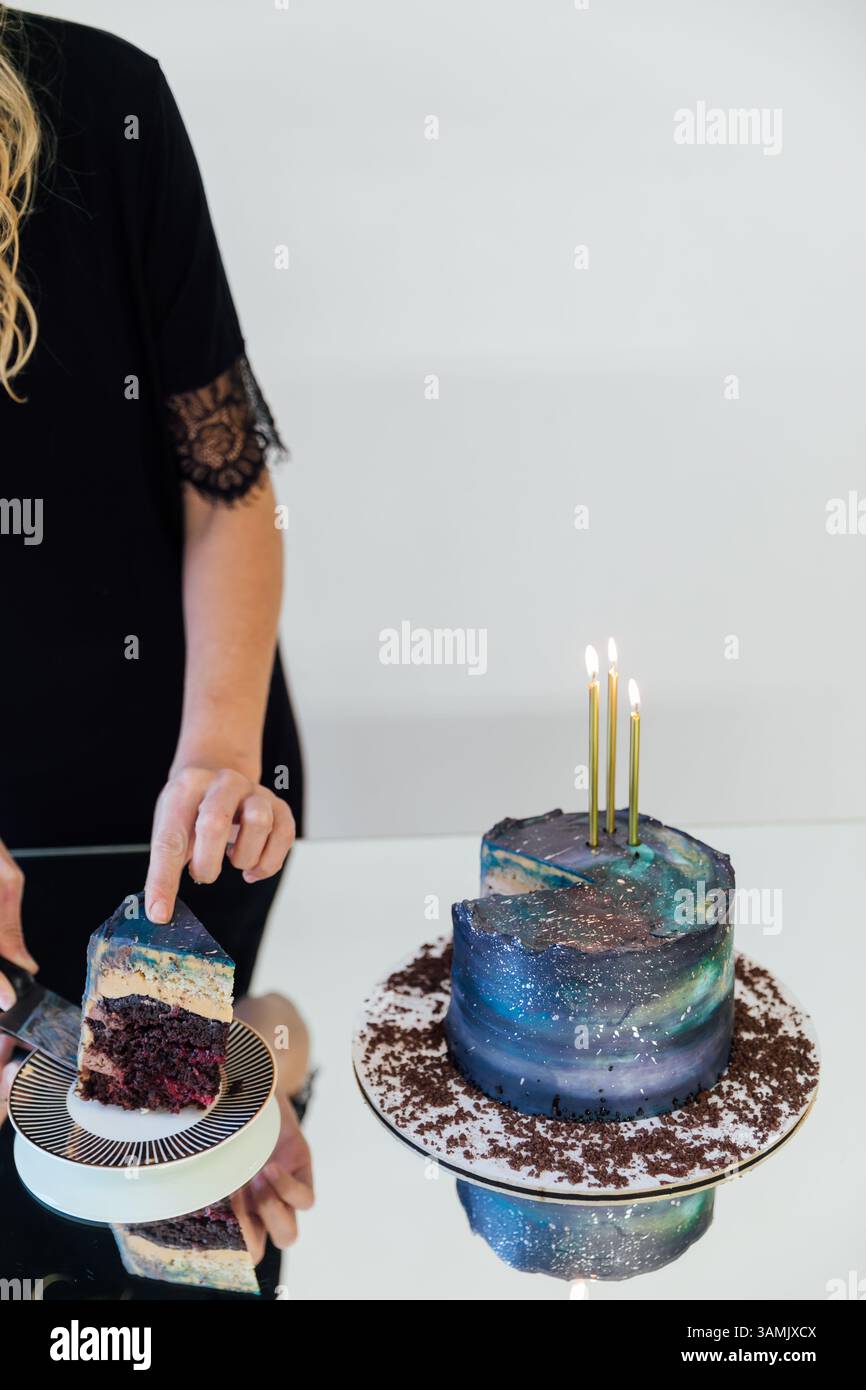 Beautiful woman cutting birthday cake and smiling Stock Photo - Alamy