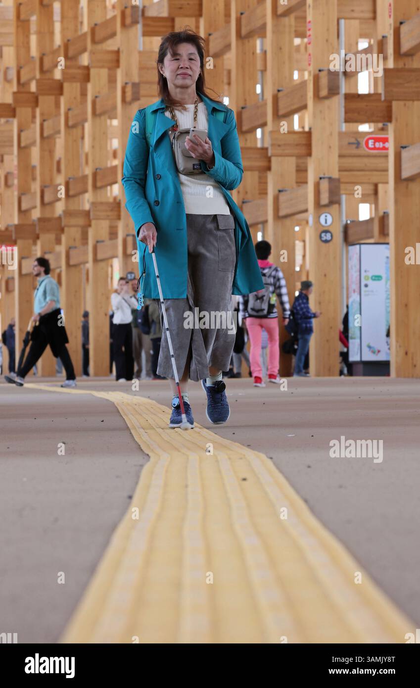 A woman makes her way to the Japan Pavilion relying on Braille blocks ...