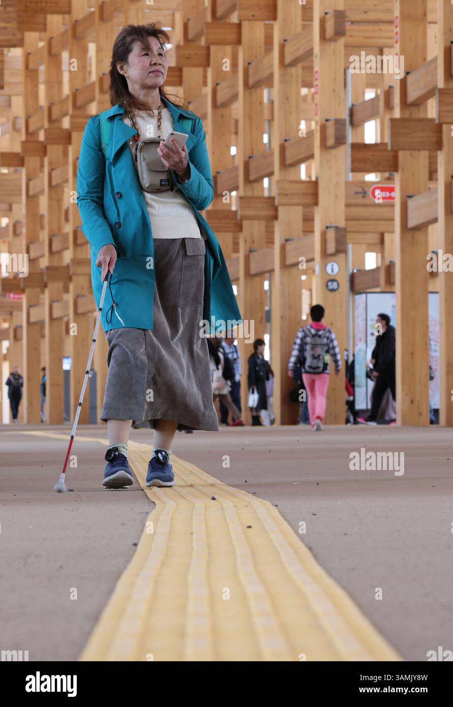 A woman makes her way to the Japan Pavilion relying on Braille blocks ...