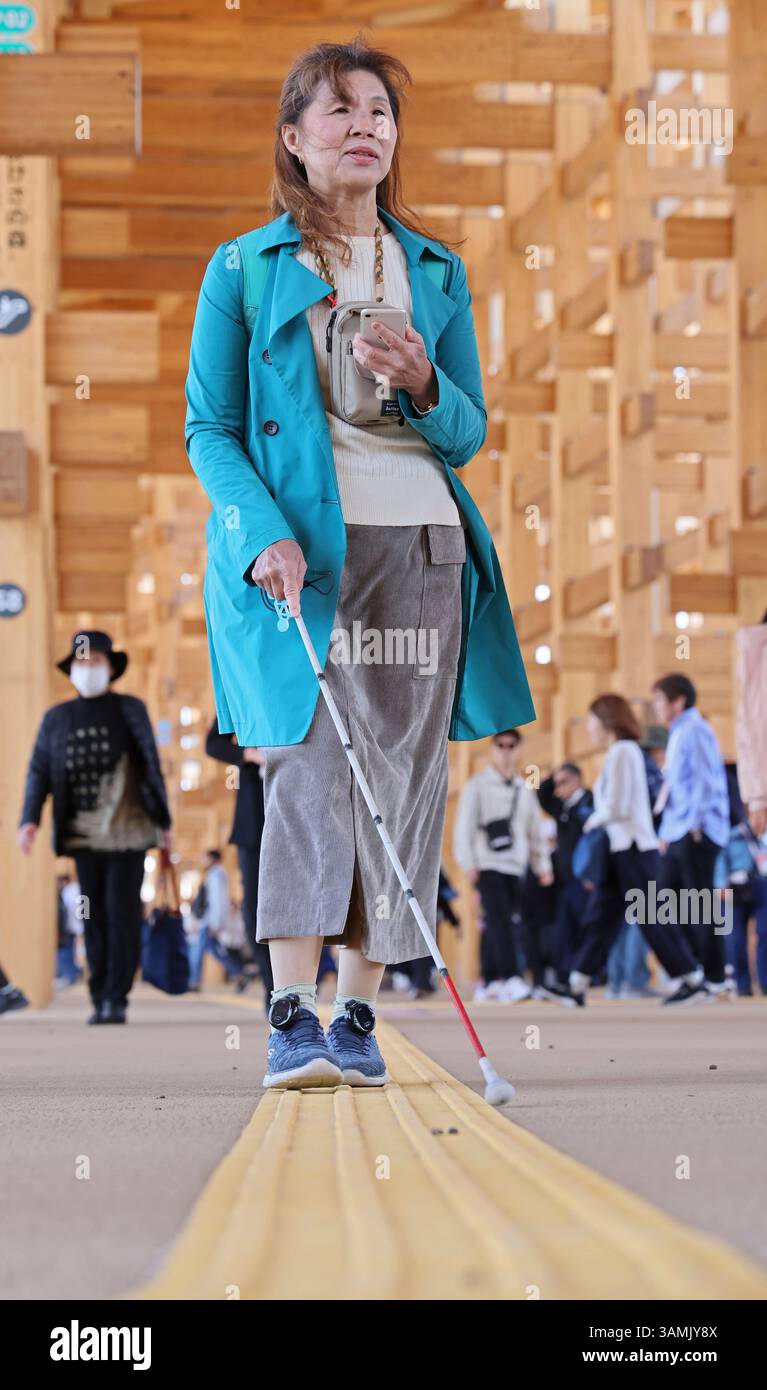 A woman makes her way to the Japan Pavilion relying on Braille blocks ...