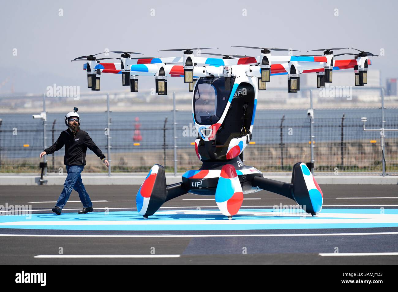 A pilot walks around a Hexa battery-powered aircraft before taking off ...