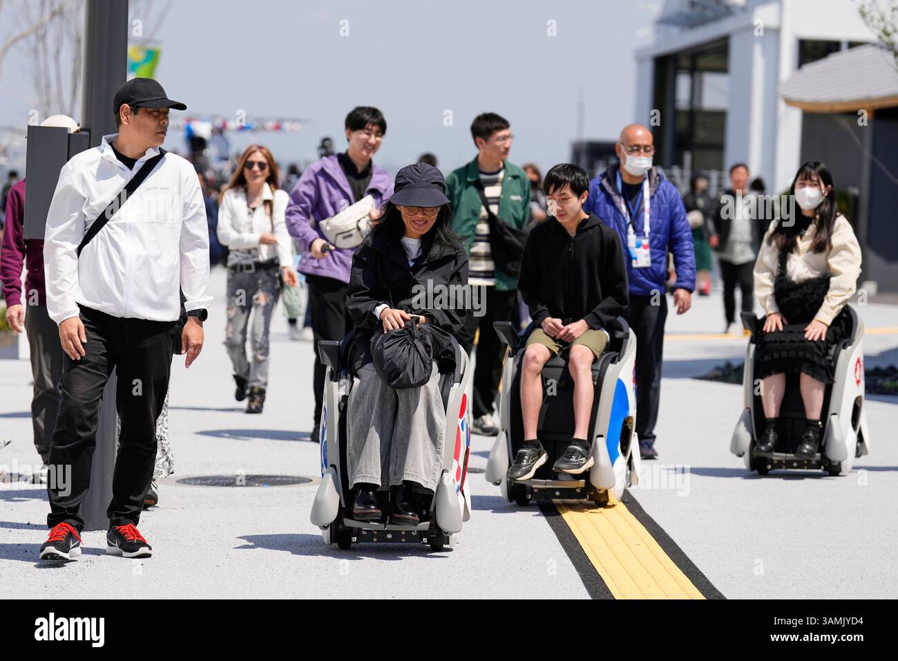 Three visitors try experiencing to maneuver UNI-ONE electric mobility ...
