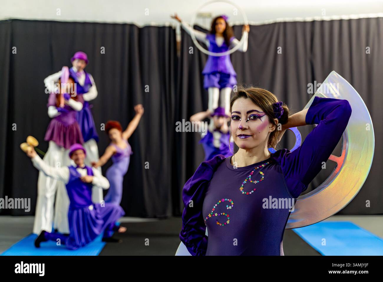 Circus performers posing in vibrant purple attire, displaying skills ...