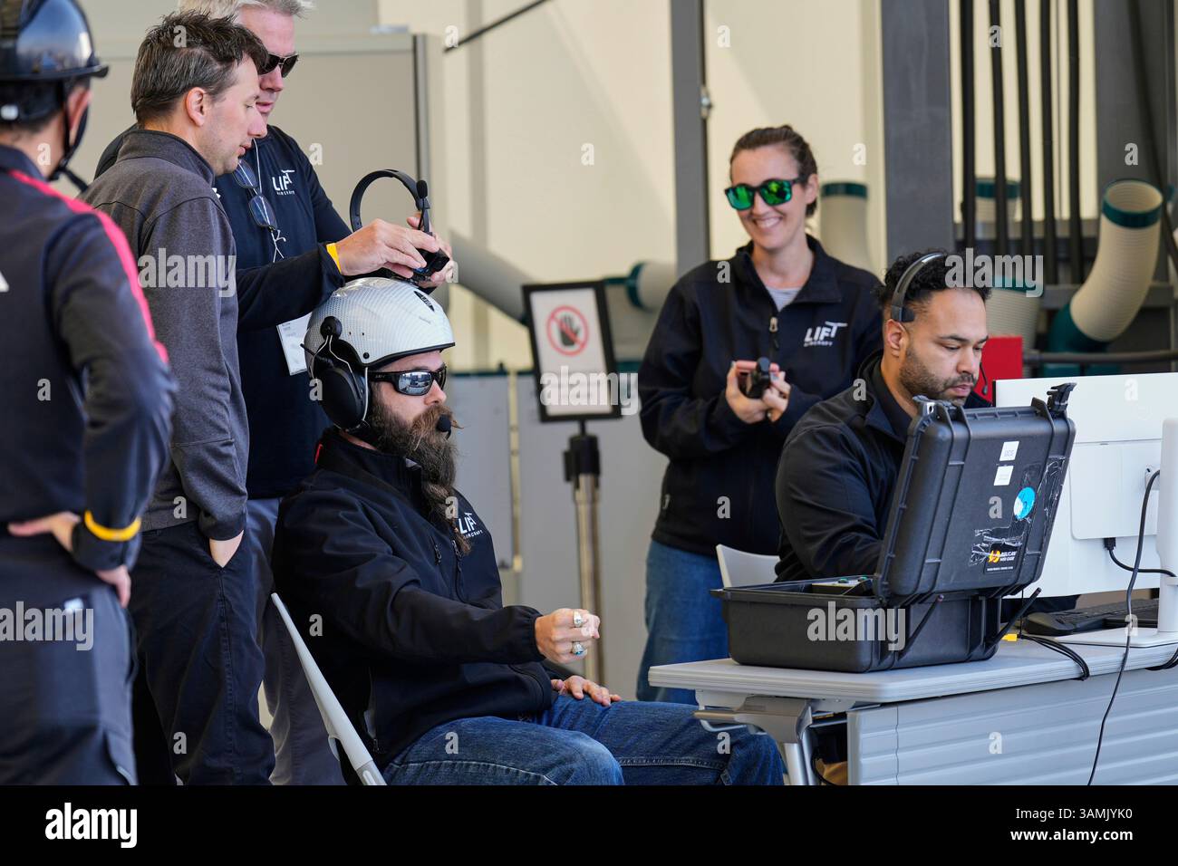 LIFT Aircraft CEO Matt Chasen, third left, puts a camera on the helmet ...