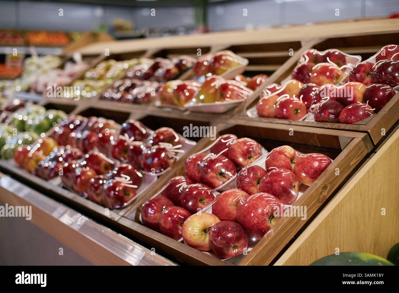 Numerous varieties of apples neatly arranged on wooden shelves in ...