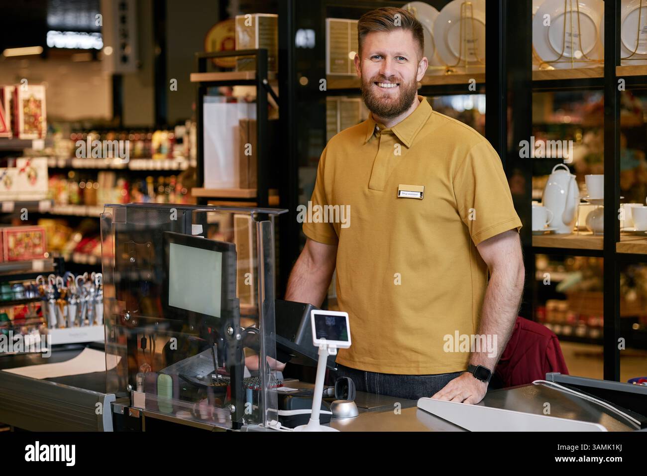 Supermarket worker smiling behind checkout hi-res stock photography and ...