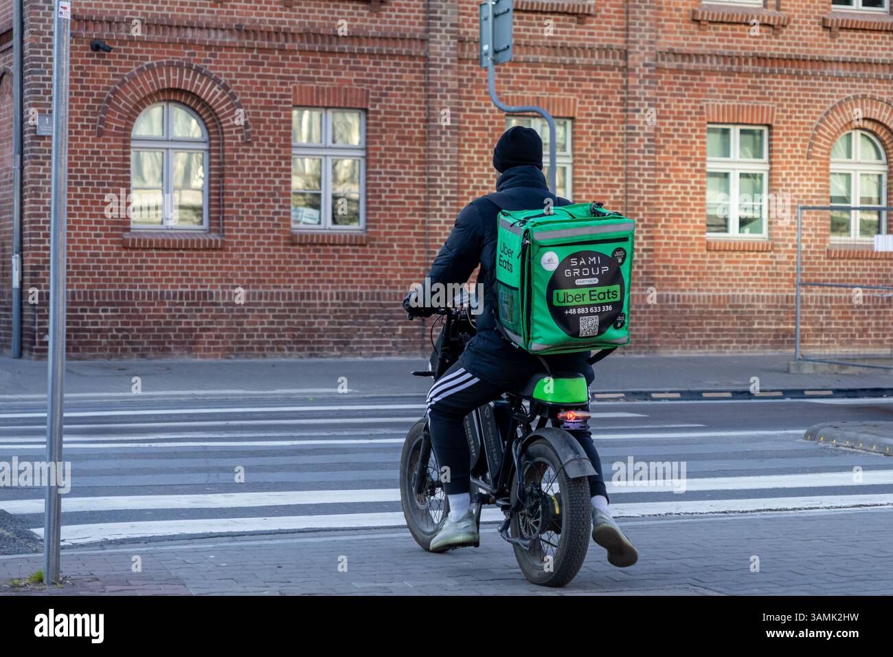 Poznan, Poland - April 8, 2025: Food delivery courier with green Uber ...
