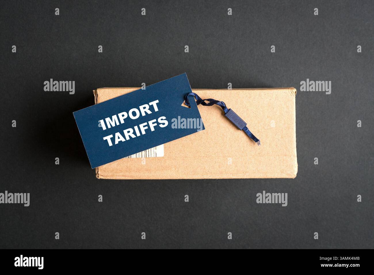 Import Tariffs, word on blue tag and top of brown cardboard package ...