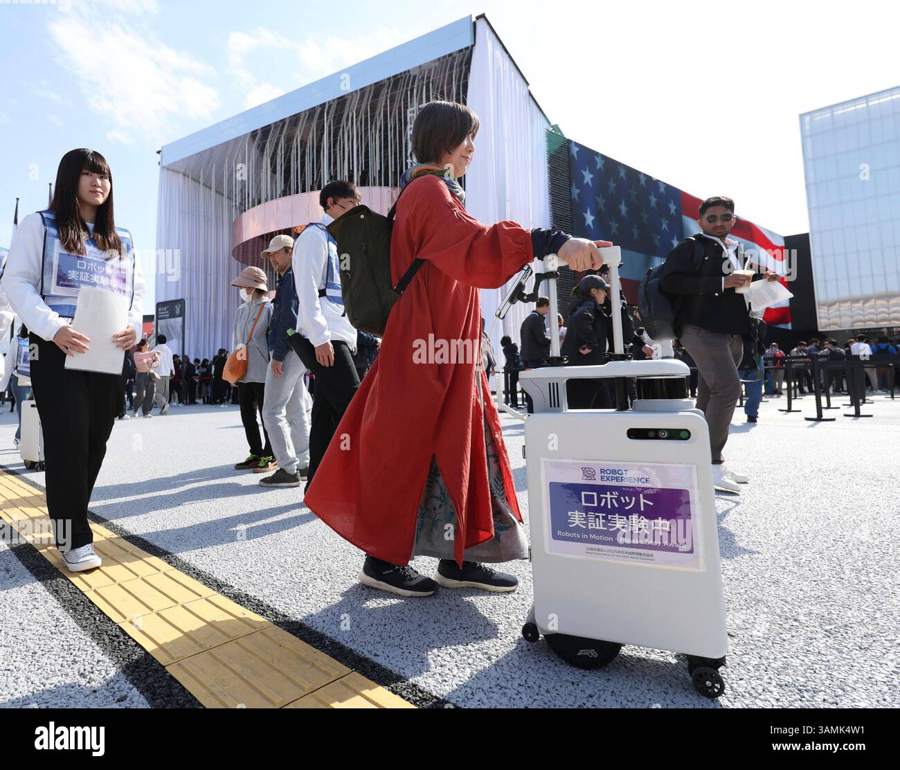 Participants experience the use of AI suitcase at a venue for Expo 2025 ...