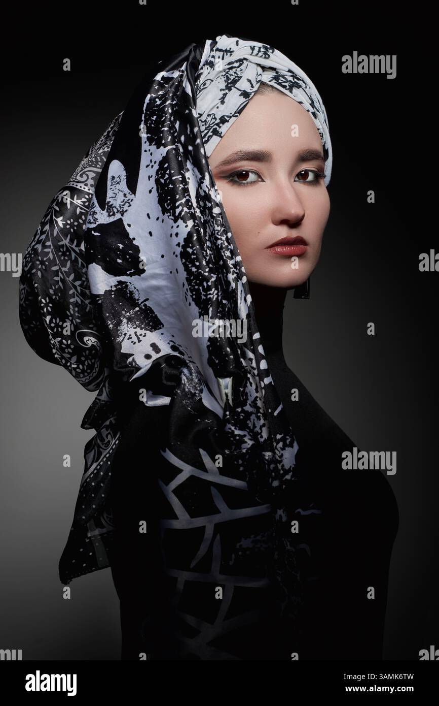 young woman poses confidently with a black and white patterned ...