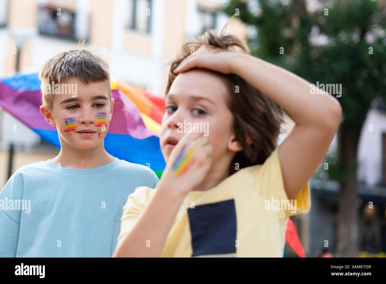 Two boys with rainbow makeup on their faces celebrating at a pride ...