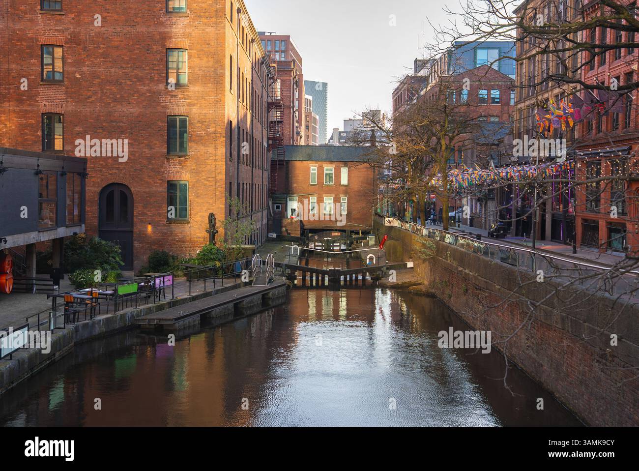 Canal Scene in Manchester with Lock, Red Brick Buildings, and Flags ...