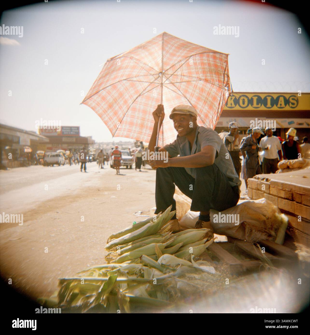 A man sells corn on the roadside in the Sowetto neighborhood of ...