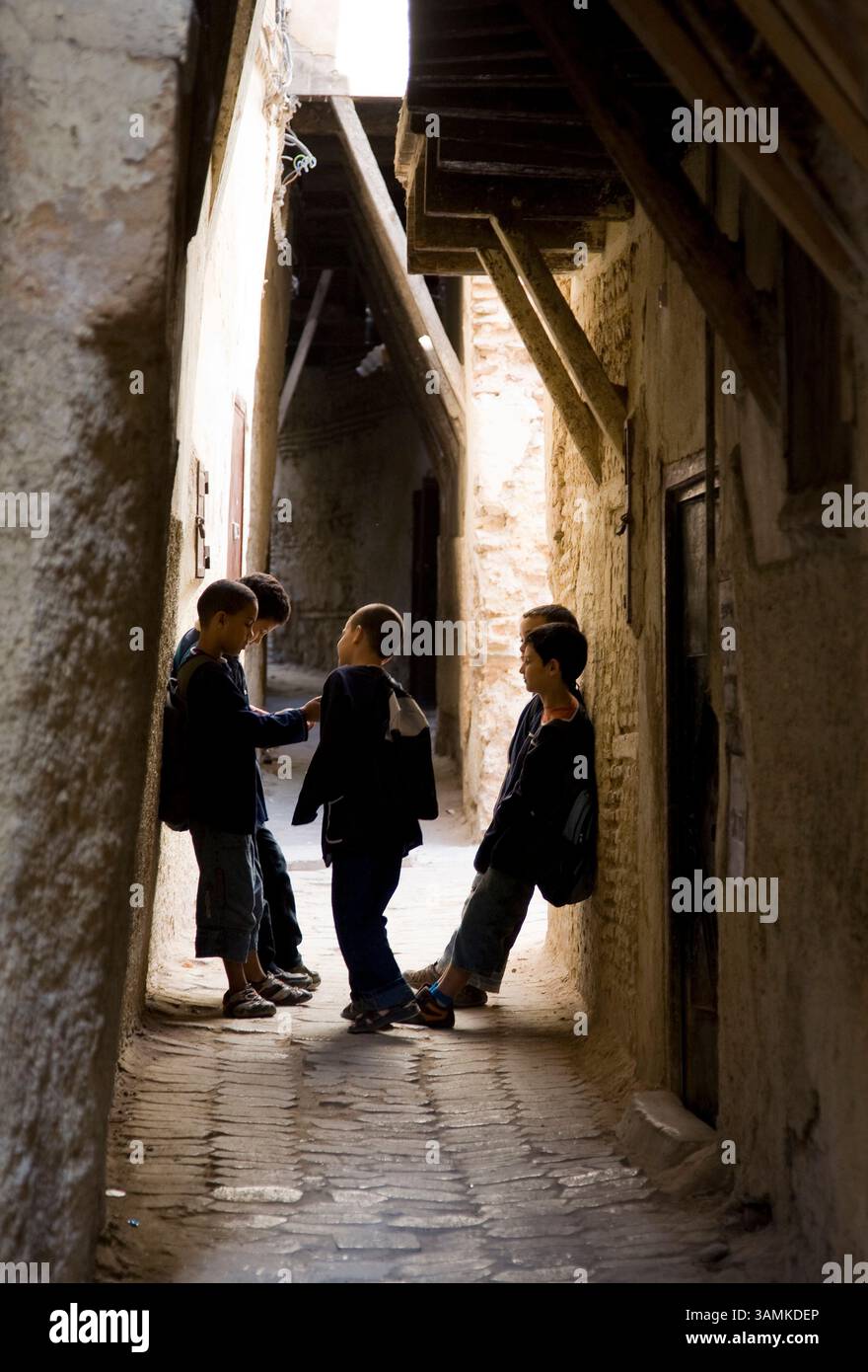 School boys gather in a narrow walkway to talk after school in Fez ...