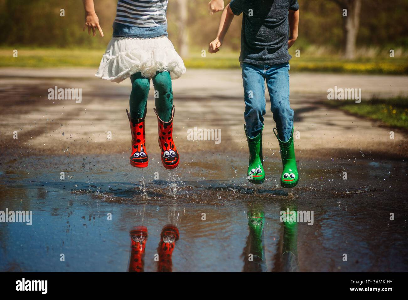 Children jumping in puddle wearing rain boots Stock Photo - Alamy
