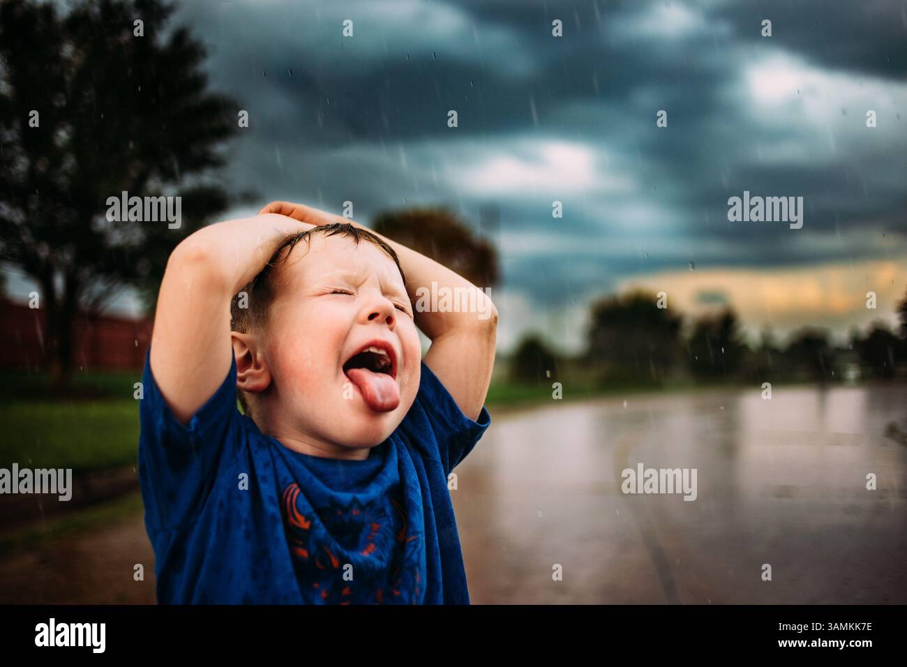 Boy catching raindrops on his tongue Stock Photo - Alamy