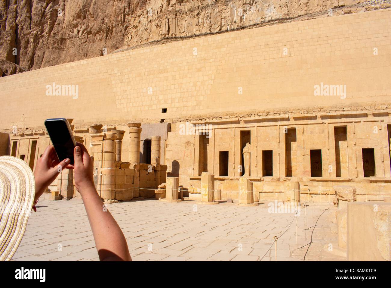 Back view of woman taking picture of Mortuary Temple of Queen ...