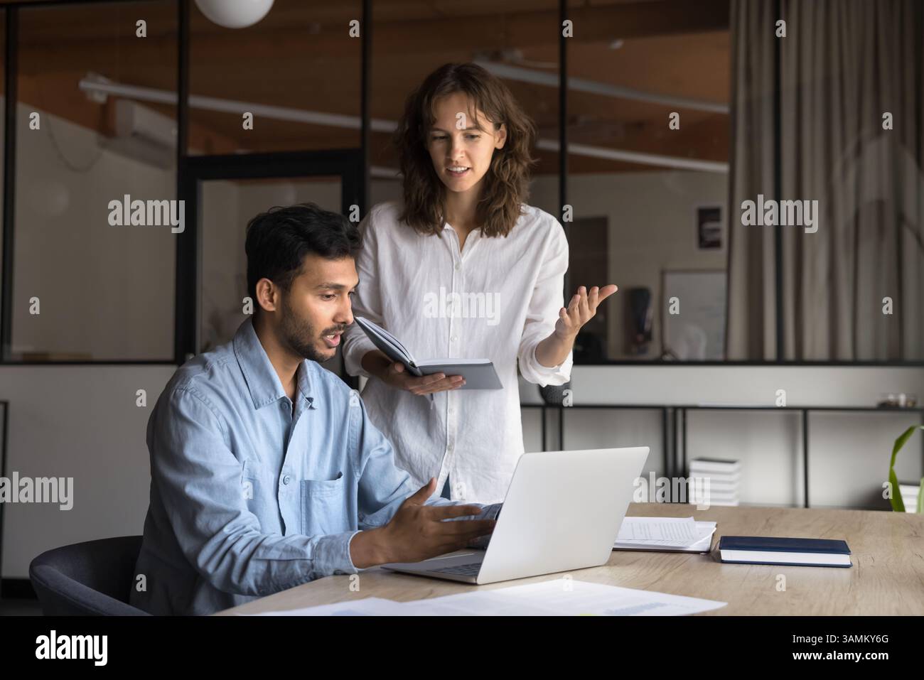 Two diverse corporate colleagues teamwork using laptop Stock Photo - Alamy