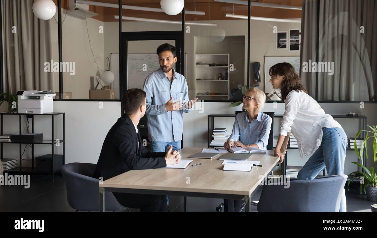 Happy Indian male leader coaching diverse business people Stock Photo ...