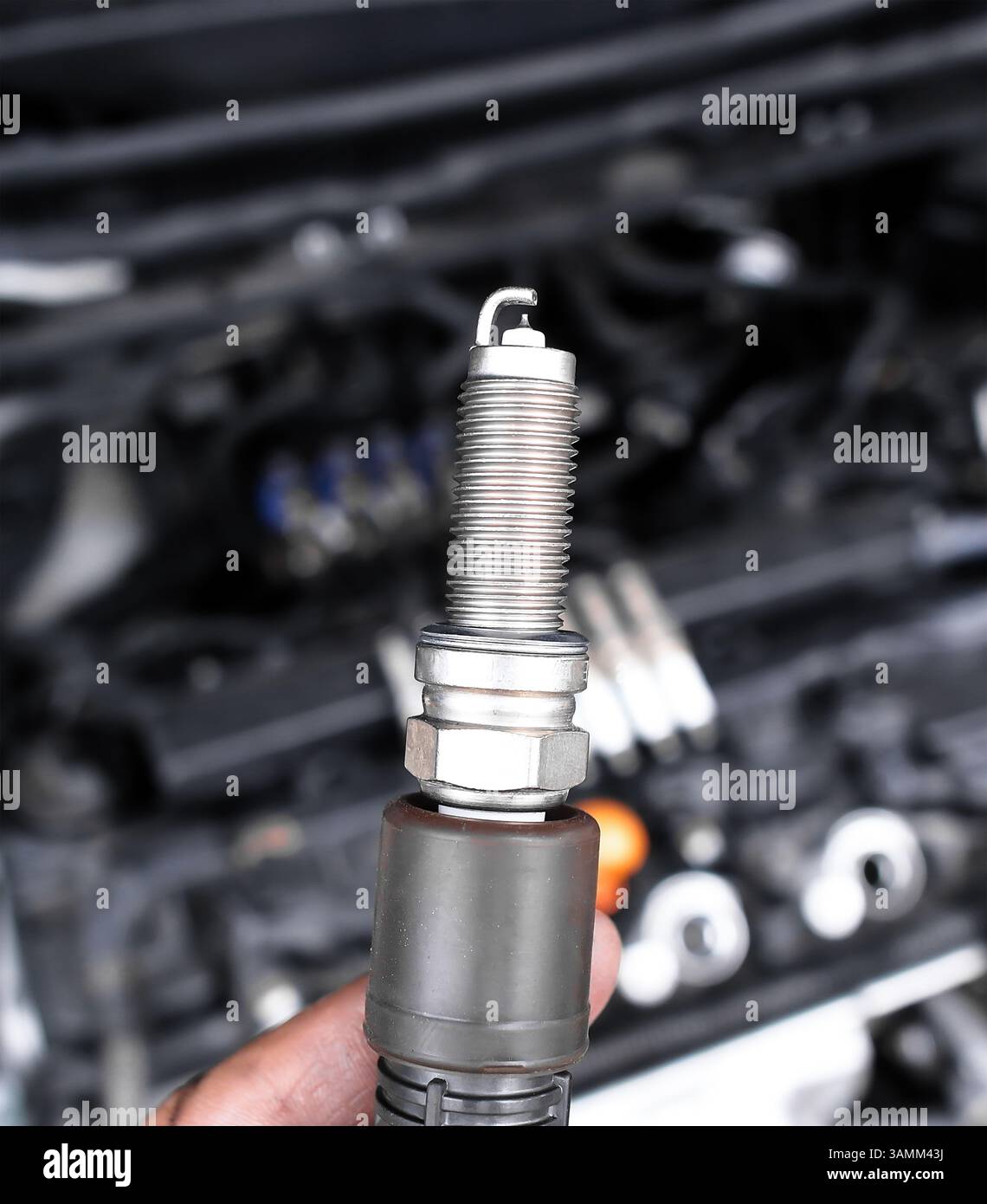 Car Spark Plug, Close up of a single iridium spark plug held in front ...