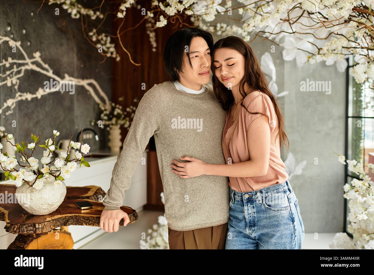 A joyful couple embraces while preparing for their wedding amid beautiful blossoms Stock Photo ...