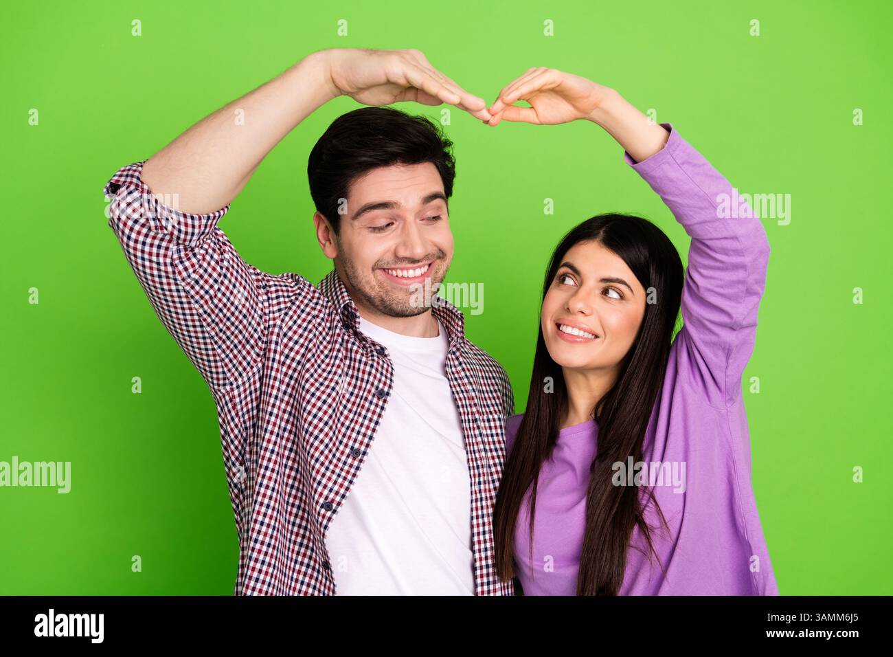 Charming young couple forming a heart shape with their hands, enjoying ...