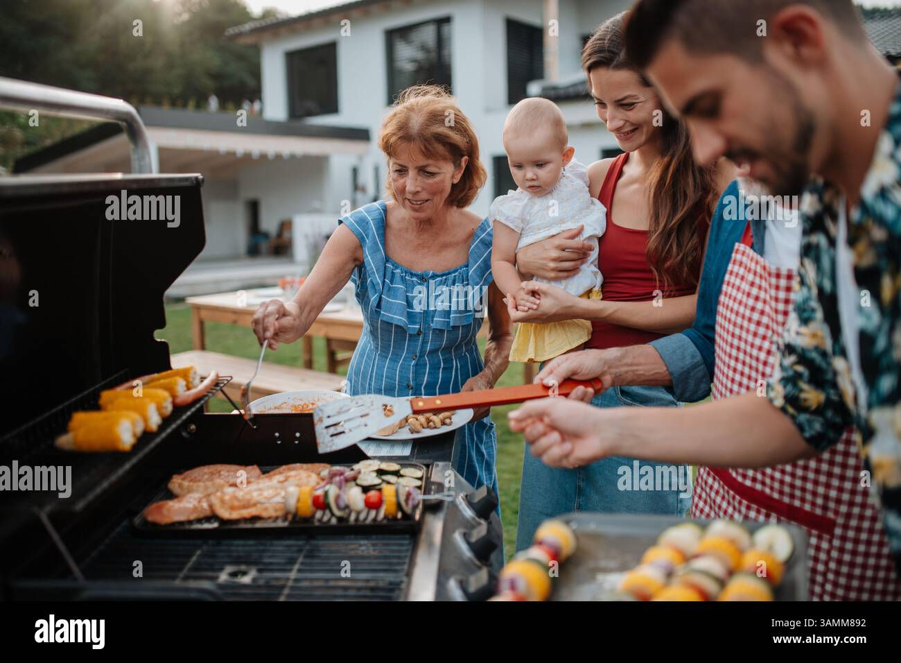 Three generations of family preparing food for a spring weekend ...