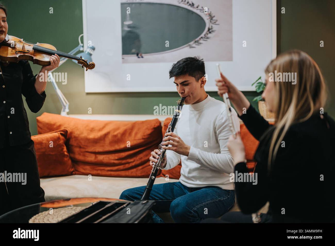 Group of young musicians practicing together in a cozy room setting ...