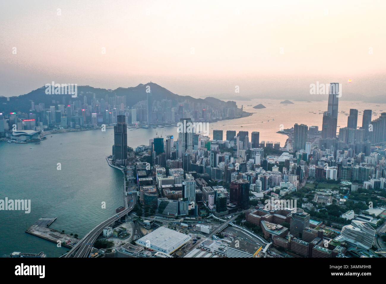 Aerial view of Hong Kong downtown skyline along the bay at sunset ...