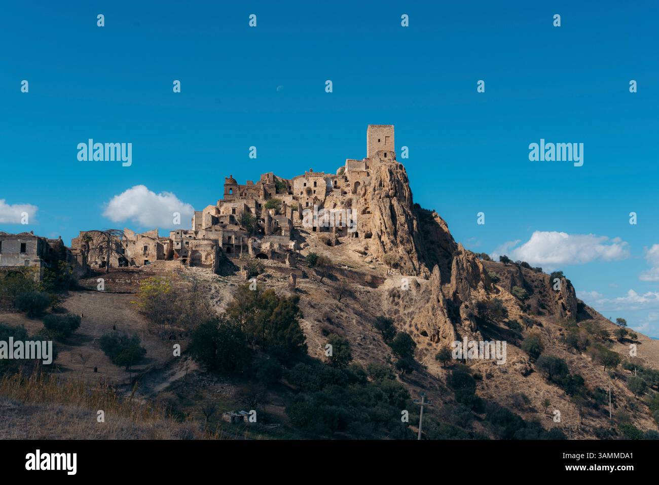 Aerial view of ancient ruins of Craco on a hilltop under a scenic sky ...