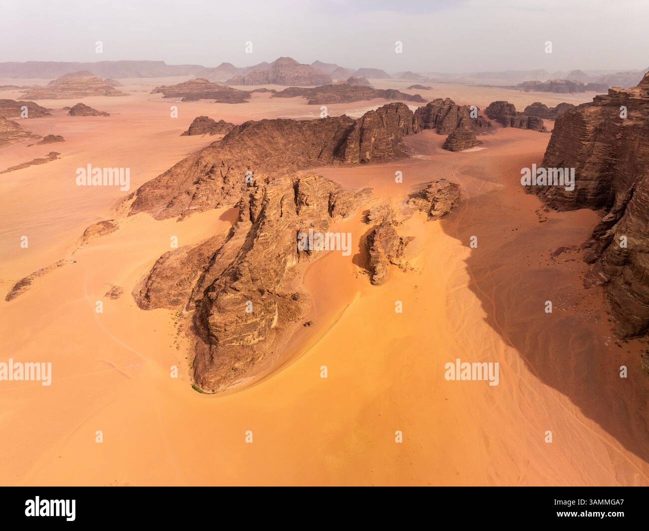 Aerial view of expansive sand dunes and rocky formations in the arid ...