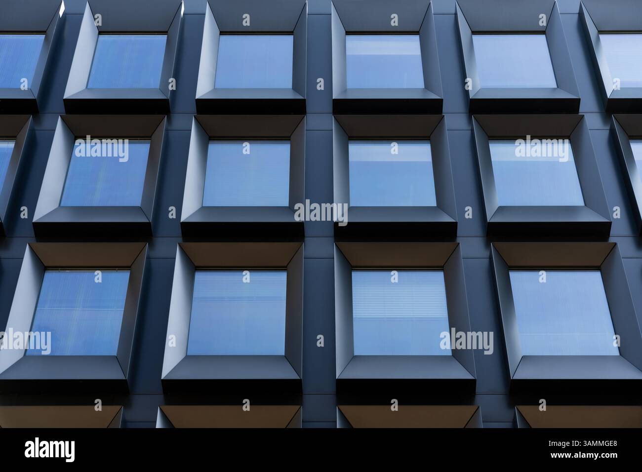 Frontal view of sleek contemporary building with deep square windows ...