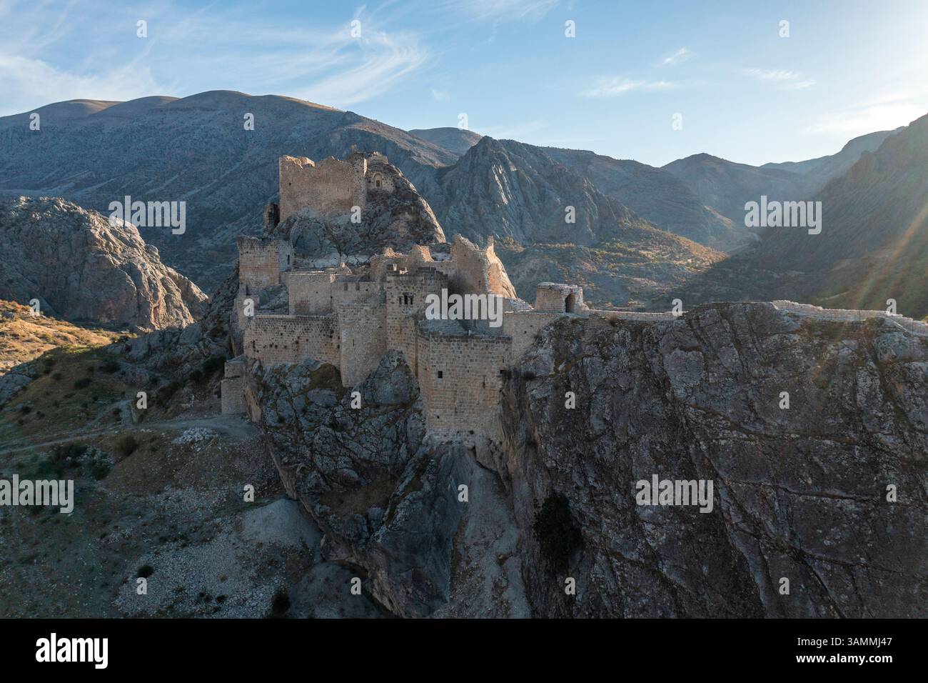 Aerial view of a majestic historic castle surrounded by rocky mountains ...