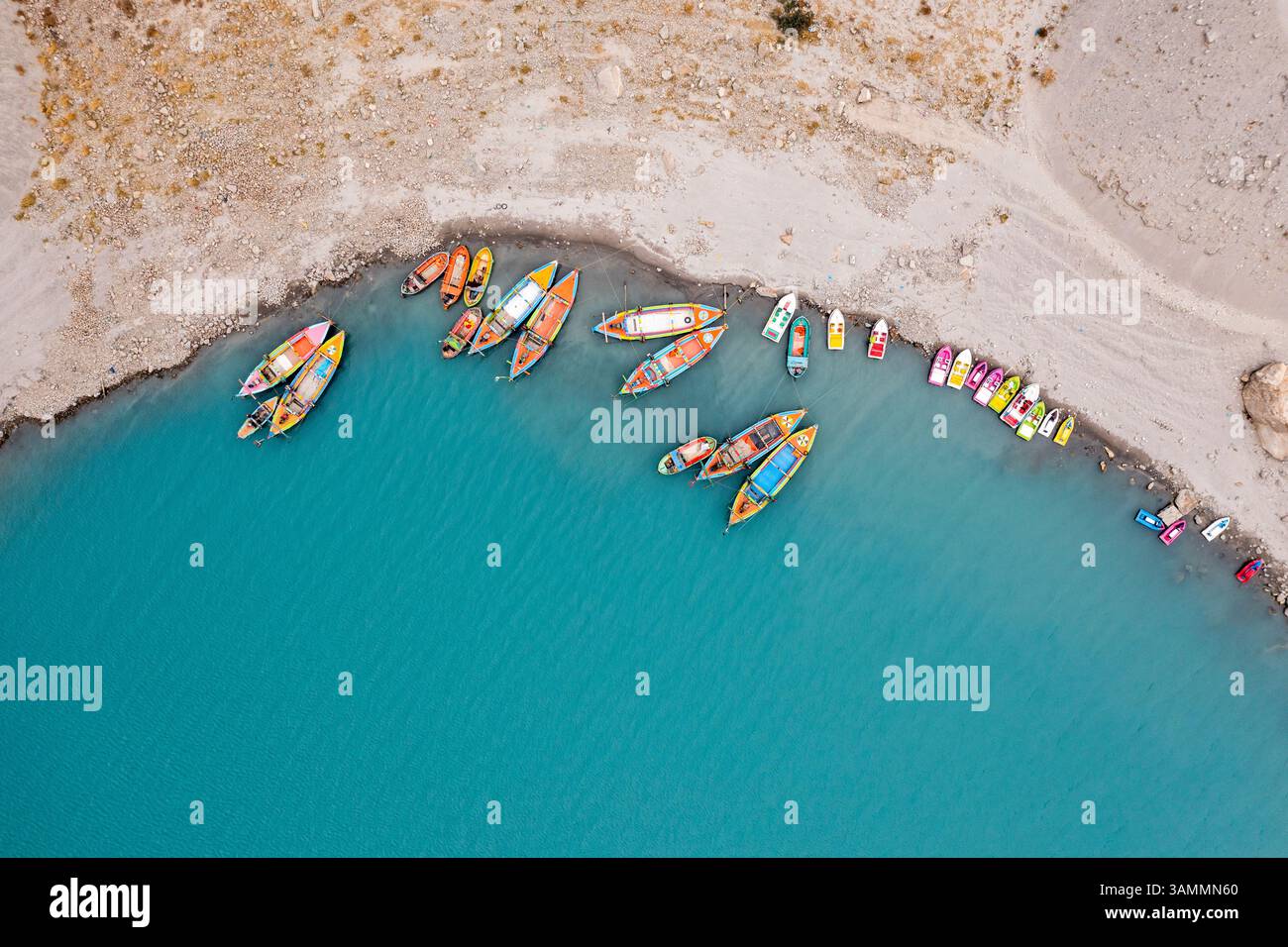 Aerial view of serene and picturesque lake with colorful boats along ...
