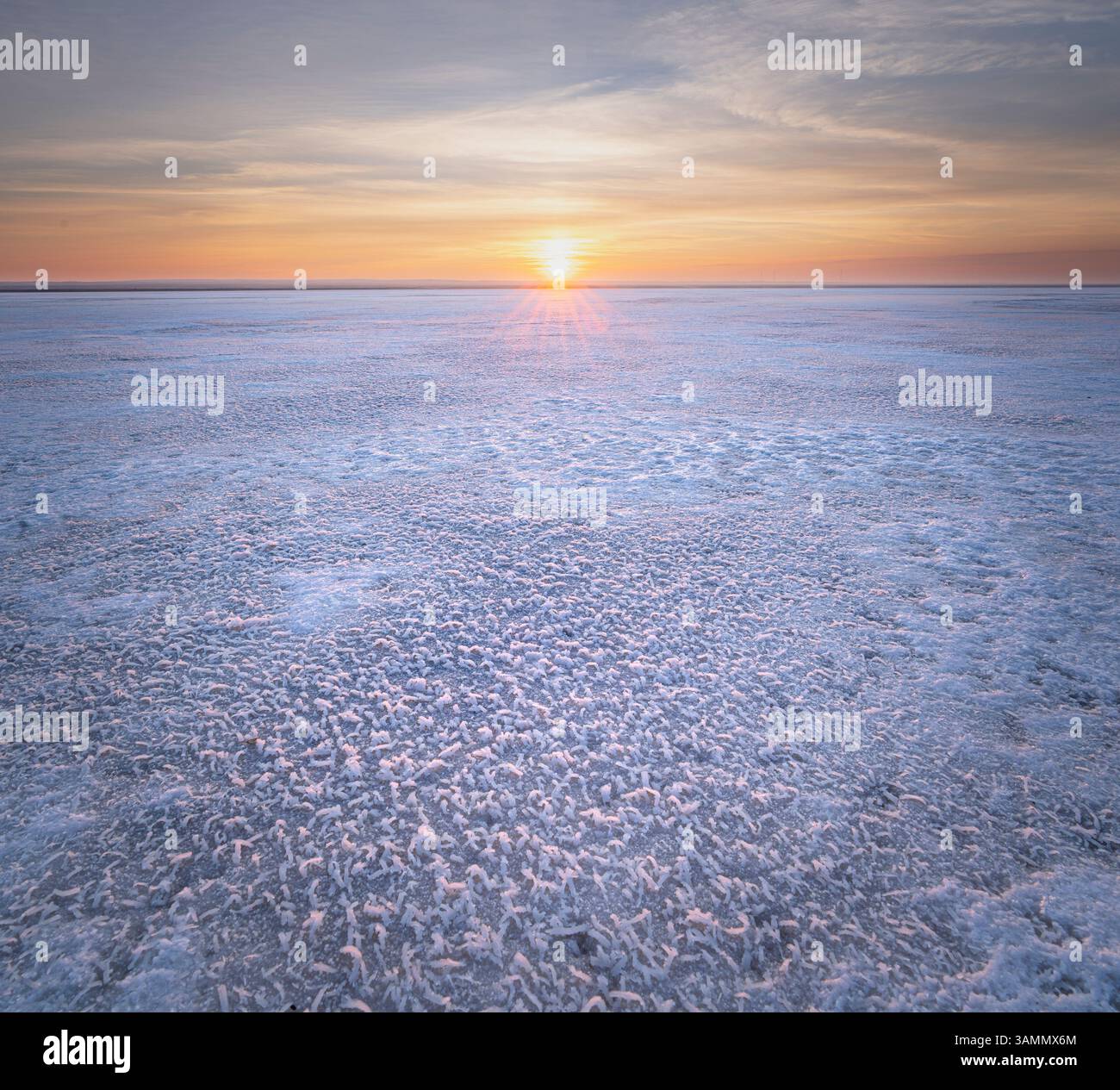 Aerial view of serene Lake Elton at sunset with frozen ice and tranquil ...