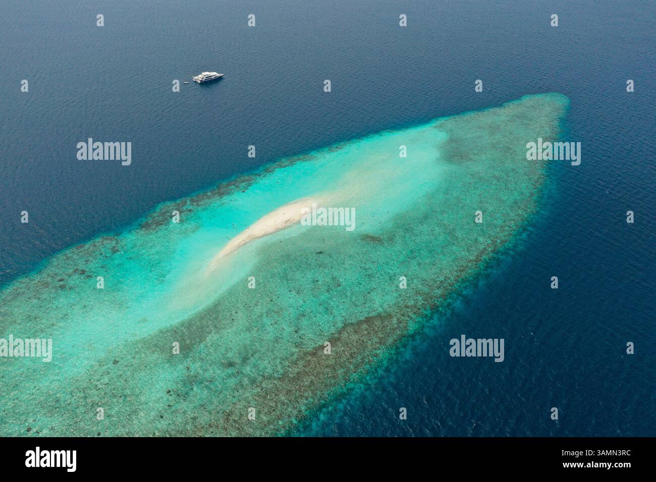 Aerial view of a small boat along the reef of Malè Atoll, Maldives ...
