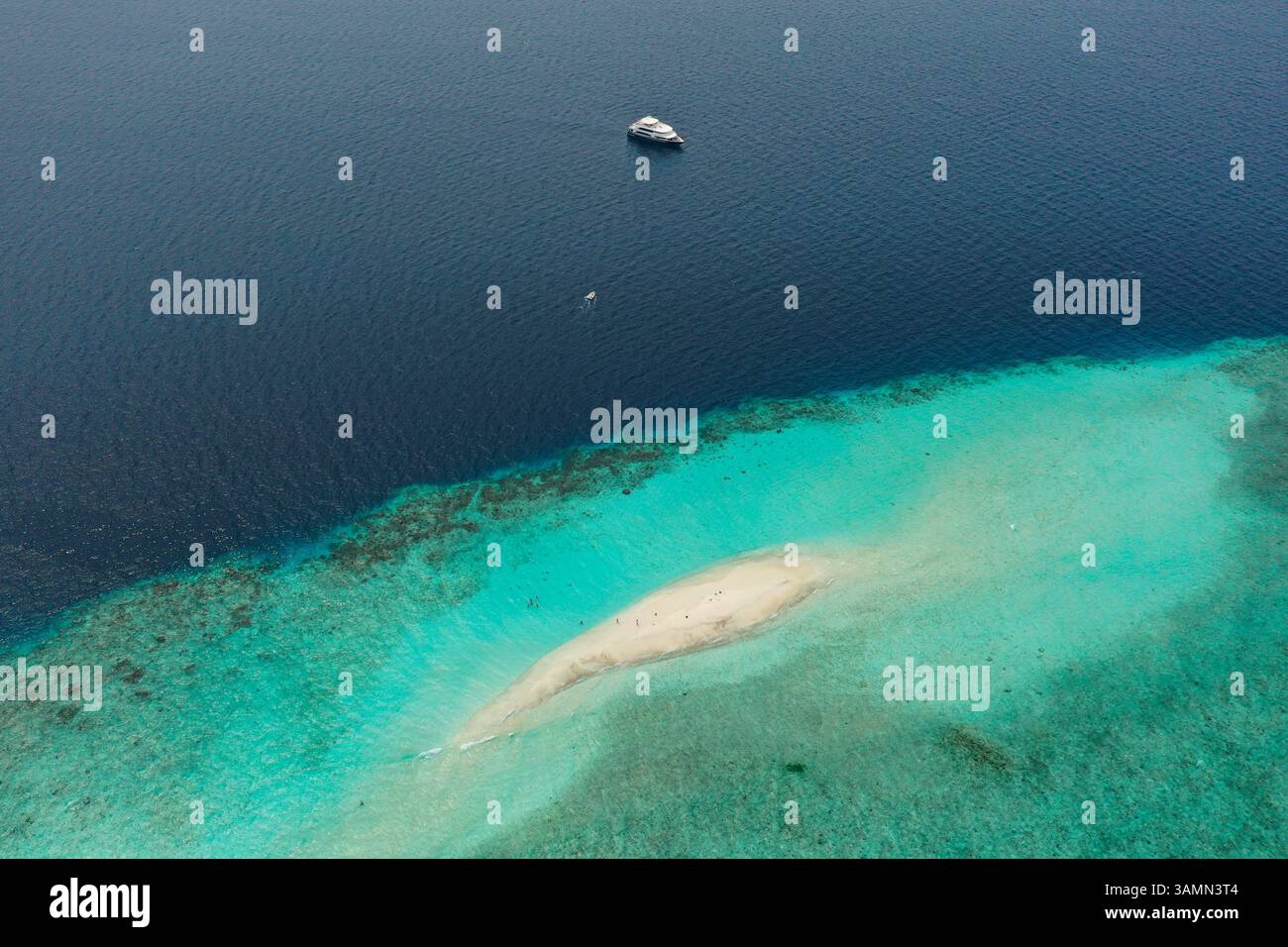 Aerial view of a small boat along the reef of Malè Atoll, Maldives ...