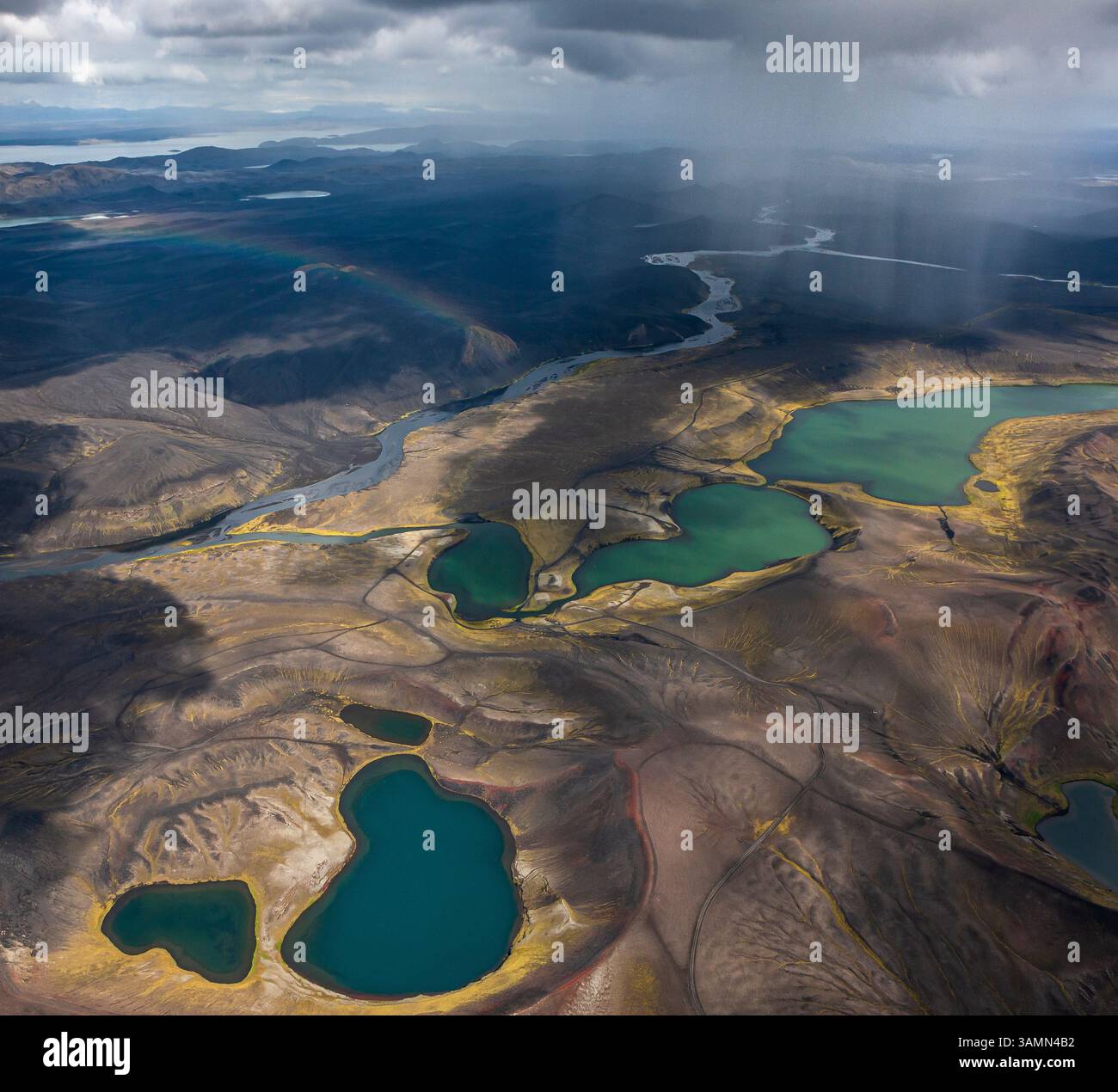 Aerial view of a river crossing the valley at sunset with lakes and ...
