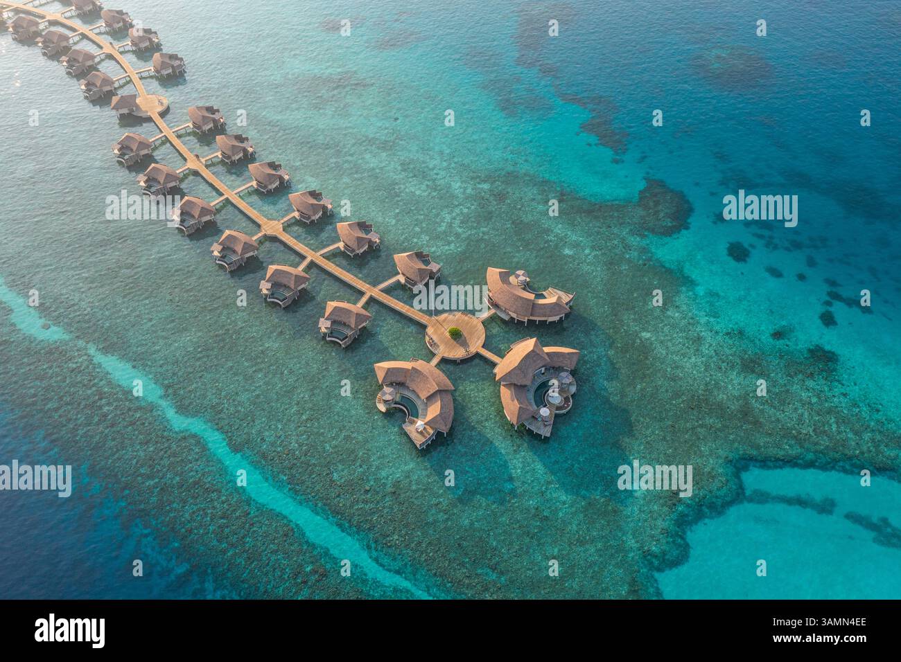 Aerial view of a luxury resort bungalows along the reef barrier on Raa ...